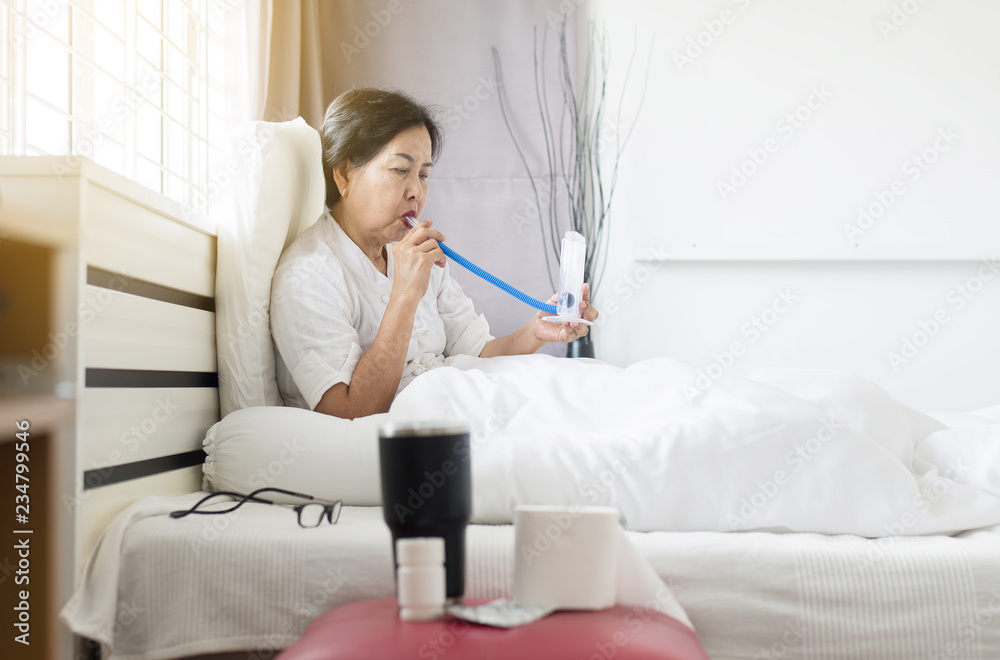 Elderly asian patient using incentive spirometer or three balls for ...