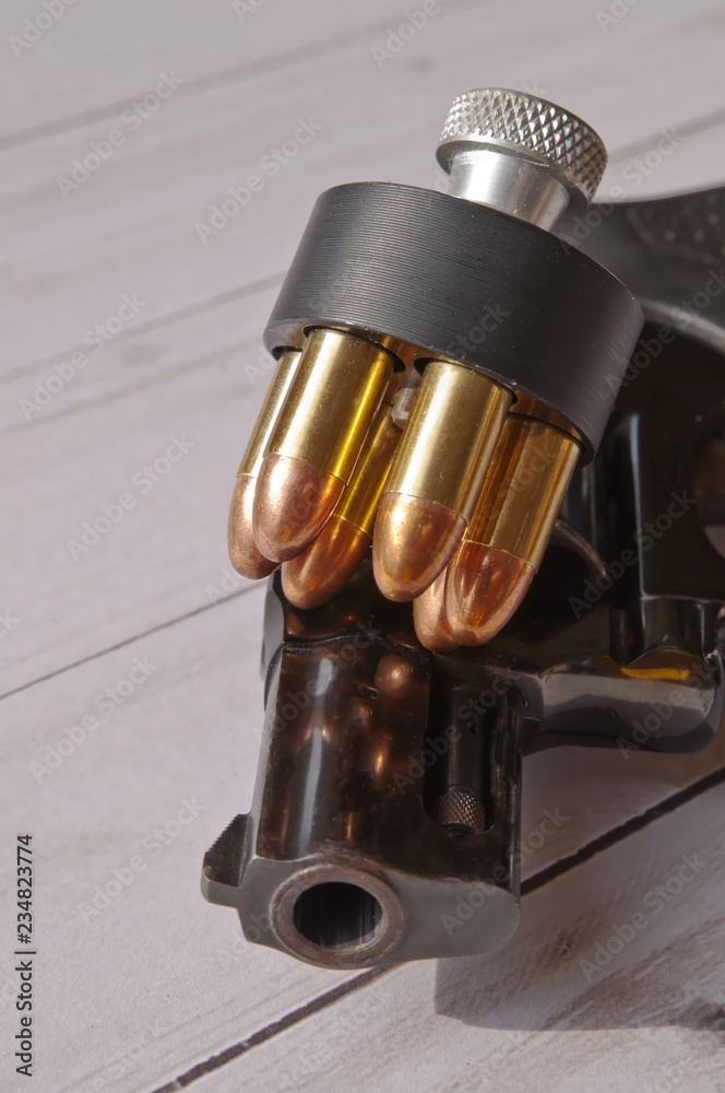 A black revolver with a loaded speed loader with 38 special full metal ...
