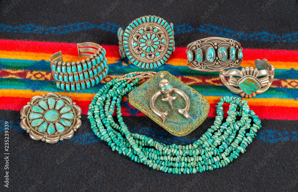 Stock Foto Collection of Native American Jewelry on a Colorful Textile Background. Turquoise and Sterling Silver Necklace Bracelets and Pendants. Adobe Stock