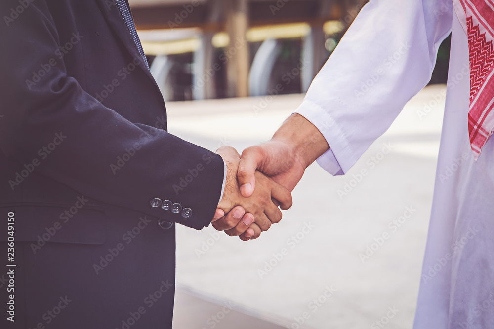 Arabic businessman giving an handshake to his business partner, on ...