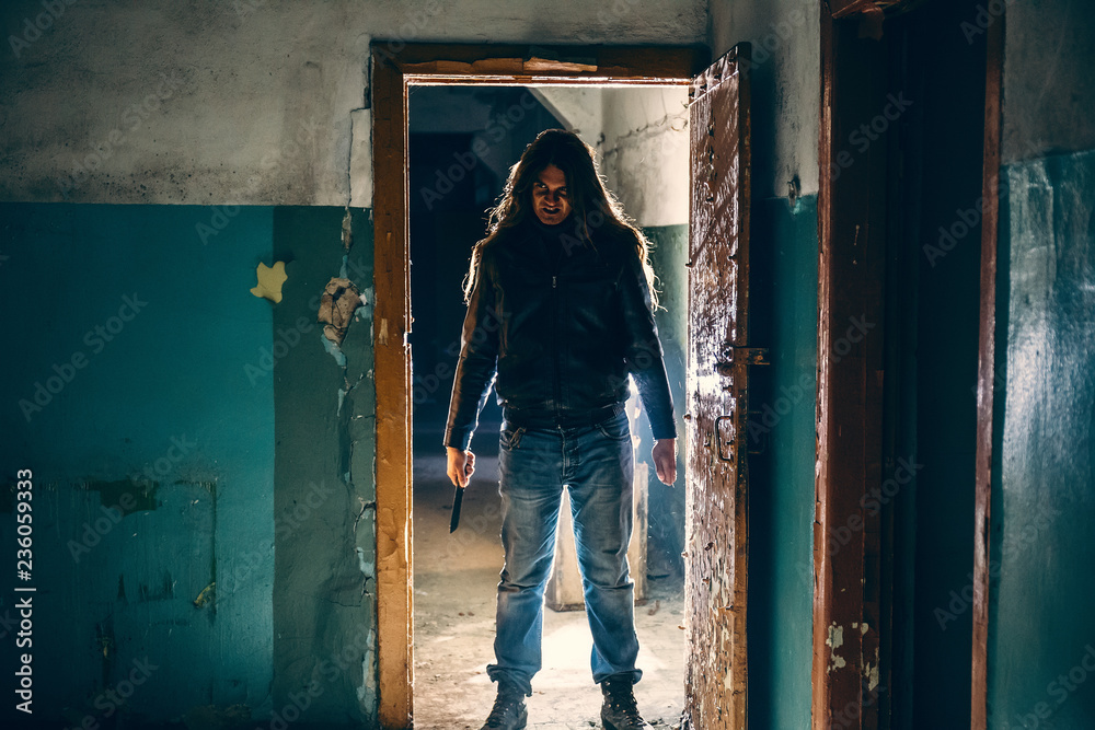 Silhouette of criminal or maniac with knife in hand in old scary ...