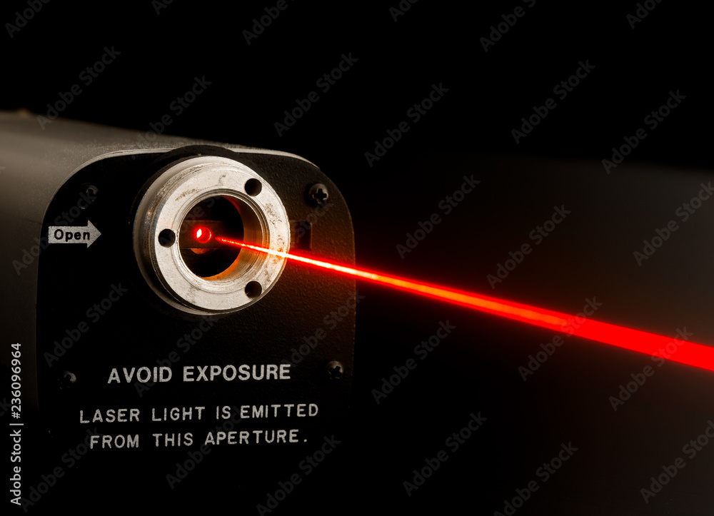 Foto de Stock Laser beam from lab laser. Warning notice on front ...