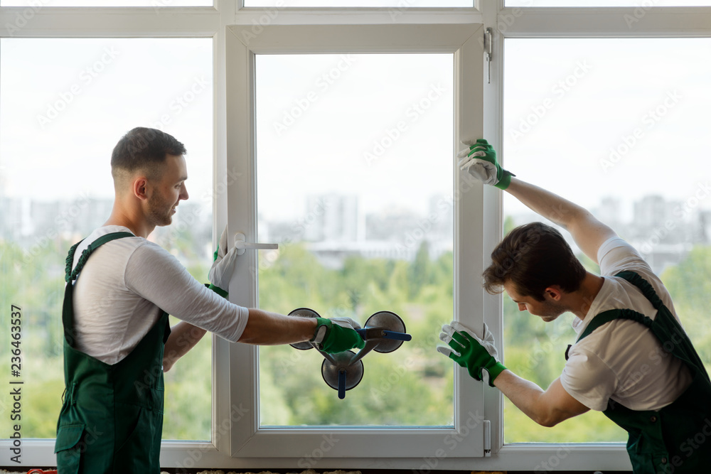 Men mounting a window section Stock Photo | Adobe Stock