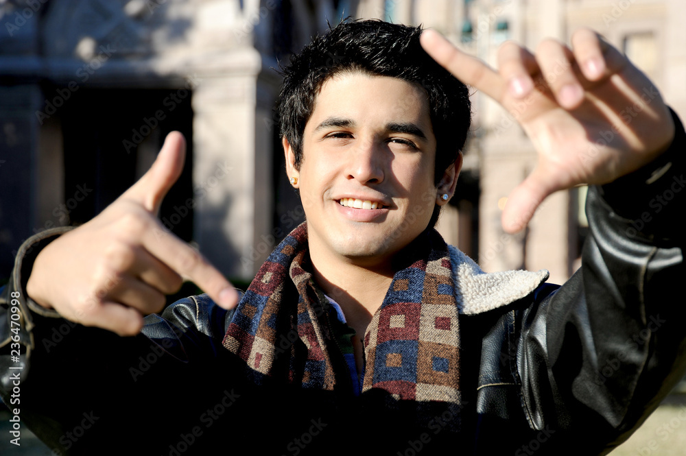 Handsome young college student using hand gestures with a big smile ...