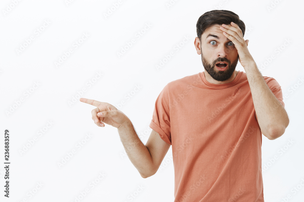 Shocked man cannot pull himself together standing impressed and worried ...