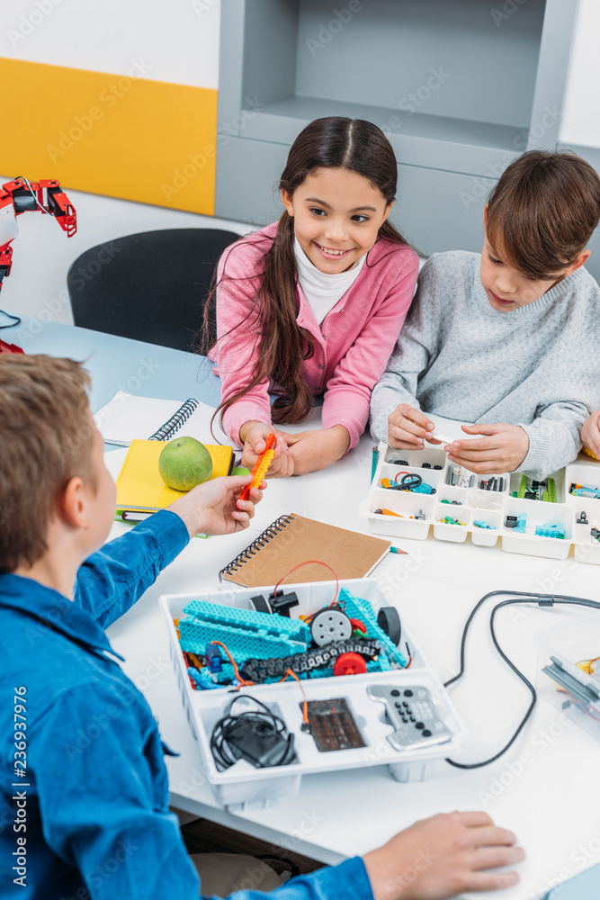 preteen schoolchildren making robot with details in stem education ...