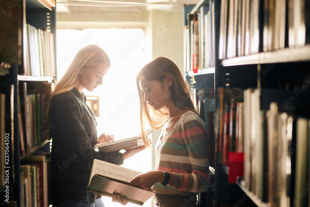 Couple of young female designers come to public library for new ideas ...