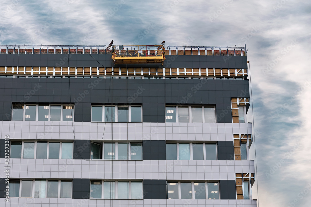 Cradle of construction crane. insulate, repair facade of house. Energy ...