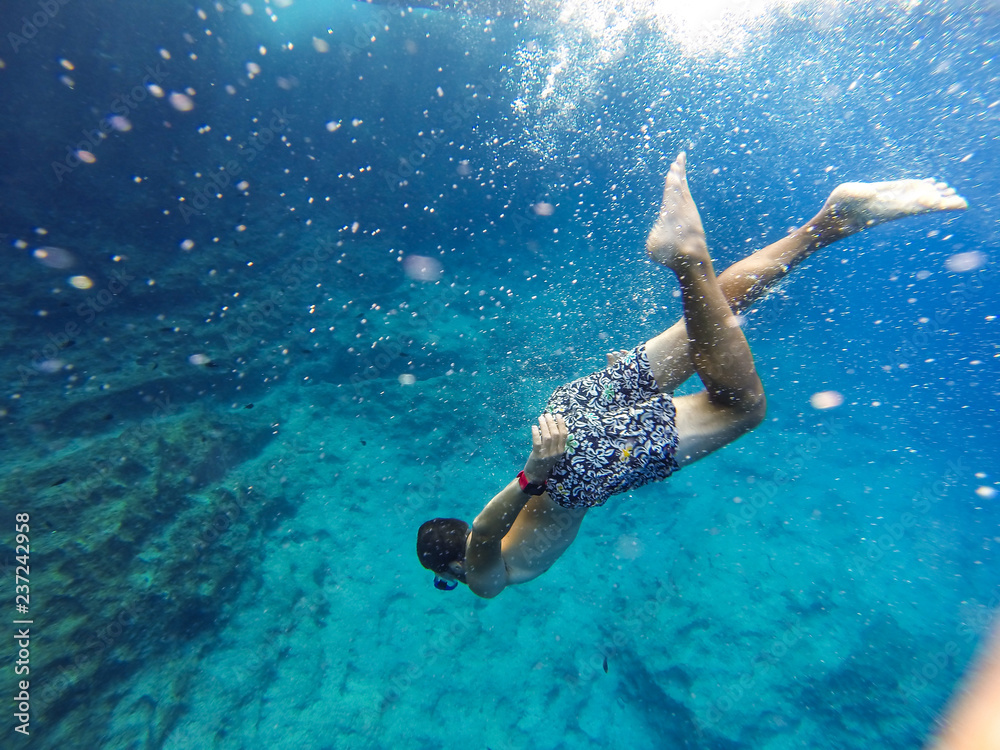 diver dives underwater, diver swims down to the bottom, snorkeling ...