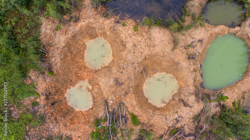 Holes on ground from powerful explosions. Bomb craters in the forest ...