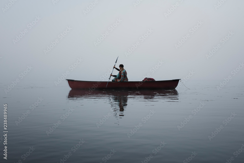 Woman rowing boat on river at Algonquin Provincial Park during foggy ...
