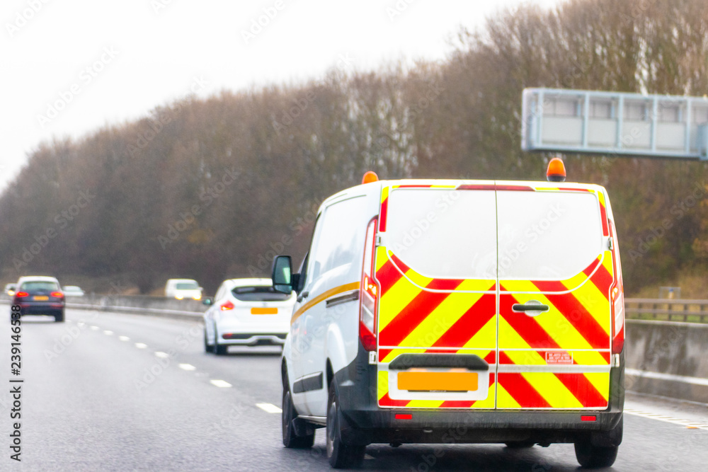 Construction Van with visibility stripes and lights on motorway ...