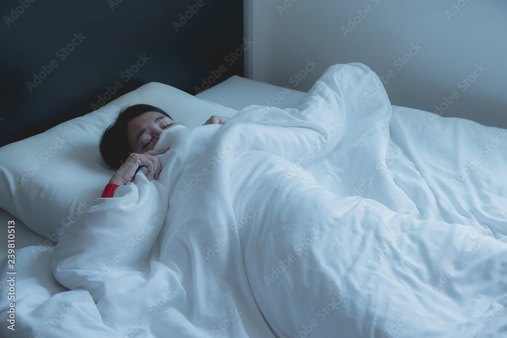 Woman with scare and panic while lying down under the blanket in ...
