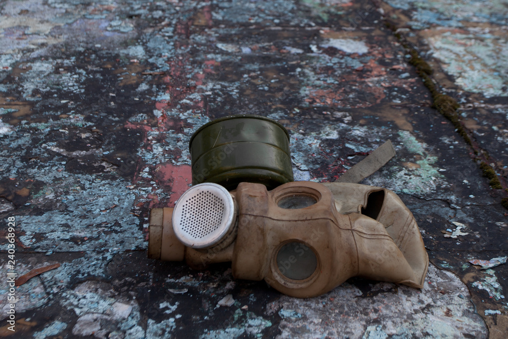 The old gas mask lies on a destroyed concrete floor, a symbol of the ...