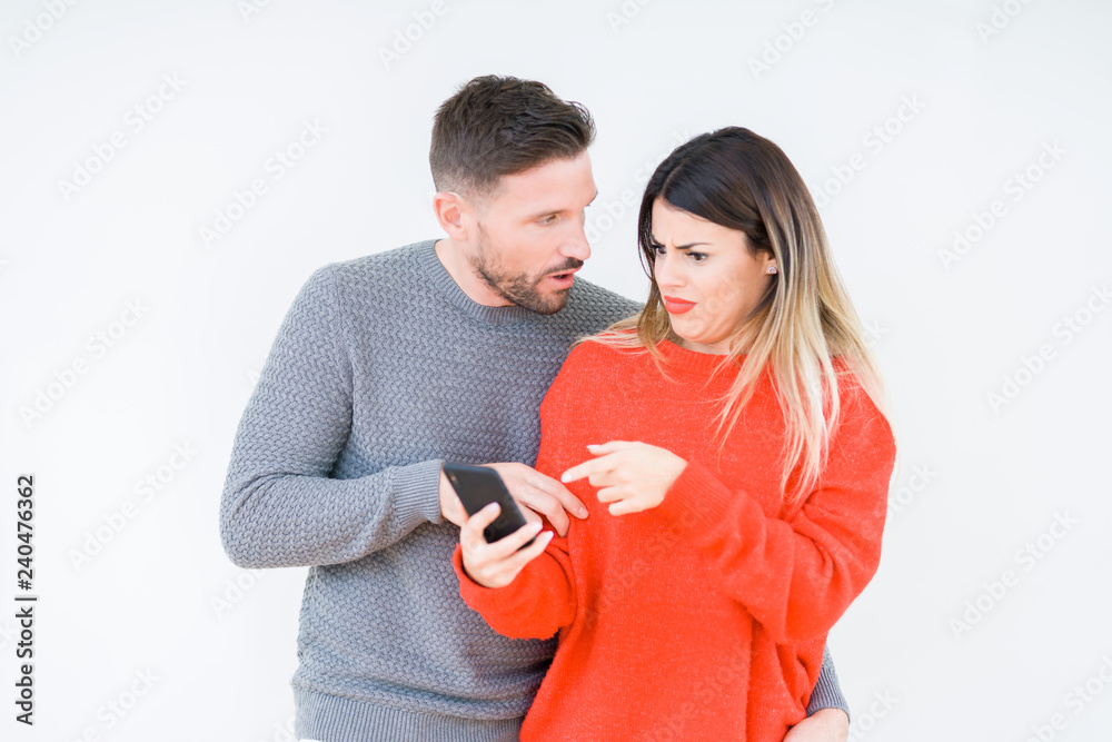 Beautiful young couple in love, kissing and hugging each other using smarthpone Stock Photo ...