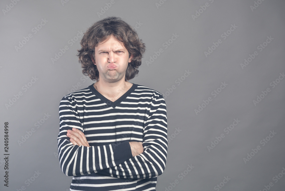 Funny comic man pouts lips and cheeks makes angry grimace, foolishes ...