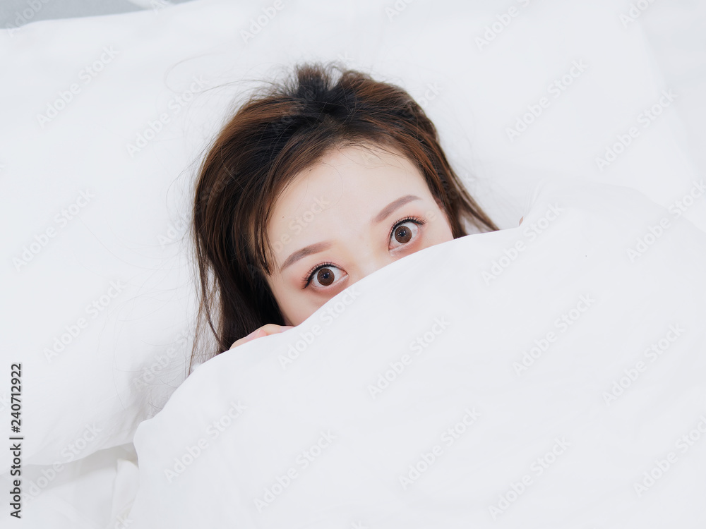 Foto Funny surprised girl covering half of face with white blanket ...