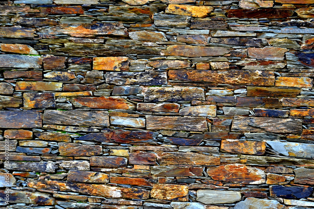 Close-up detail view of an old traditional stone wall built from schist ...