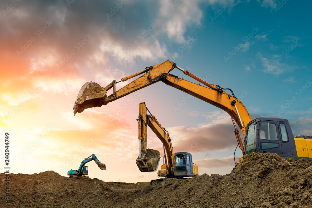Three excavators work on construction site at sunset Stock Photo ...