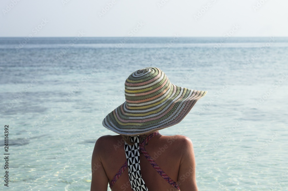 Girl with a straw hat and a swimsuit in a desert island (Ari Atol ...