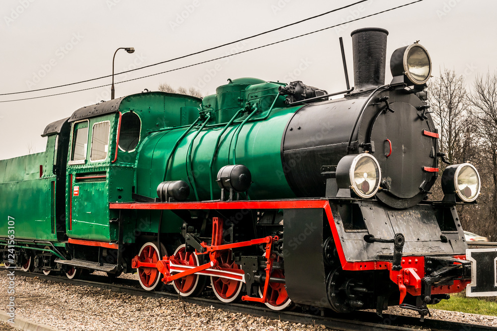 A green steam locomotive engine on display in Marki, Poland. The narrow ...