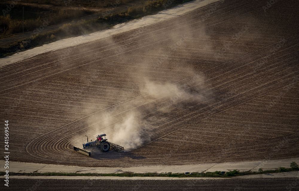 Foto de Stock Tractor turning cassava roots, showing pollution caused ...