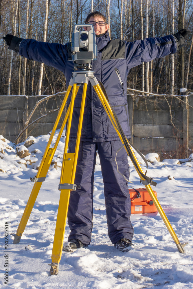 Surveyor conducts a topographical survey for the cadastre at a ...