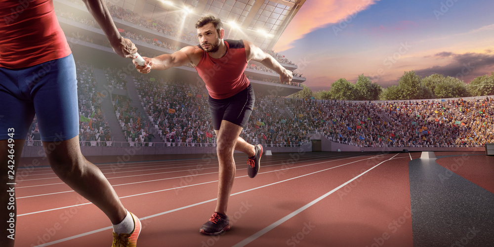 Male athletes sprinting. Runner passes the baton at the running track ...