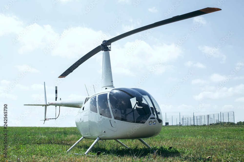 Small light helicopter parked on grass airport. Most popular light ...