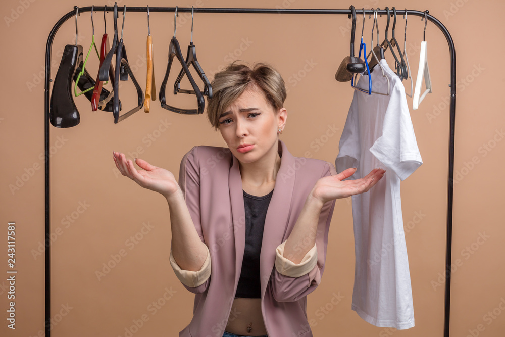 sad girl doesn't know what to wear. girl is shrugging shoulders as she ...