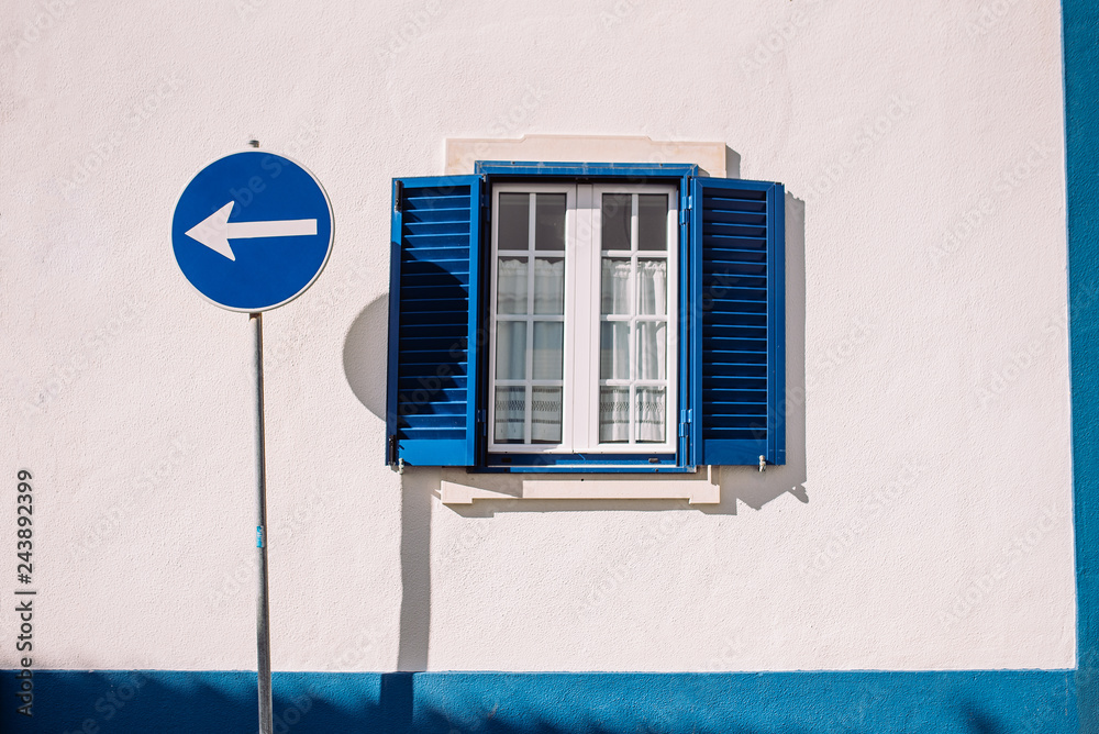 Blue arrow traffic sign turn left in the town. Road signs in the ...