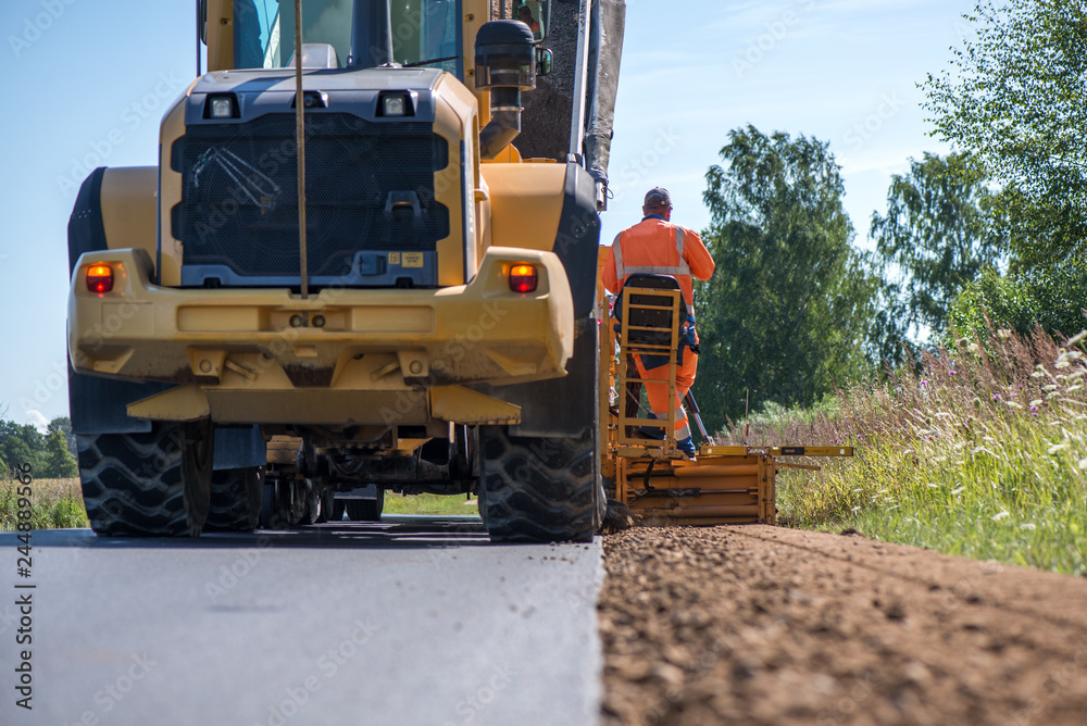 Road construction workers repairing highway road on sunny summer day ...