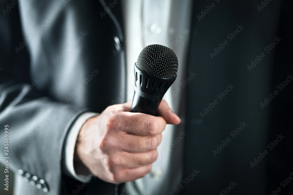 Fotografie Business man holding microphone. Public speaking and giving ...