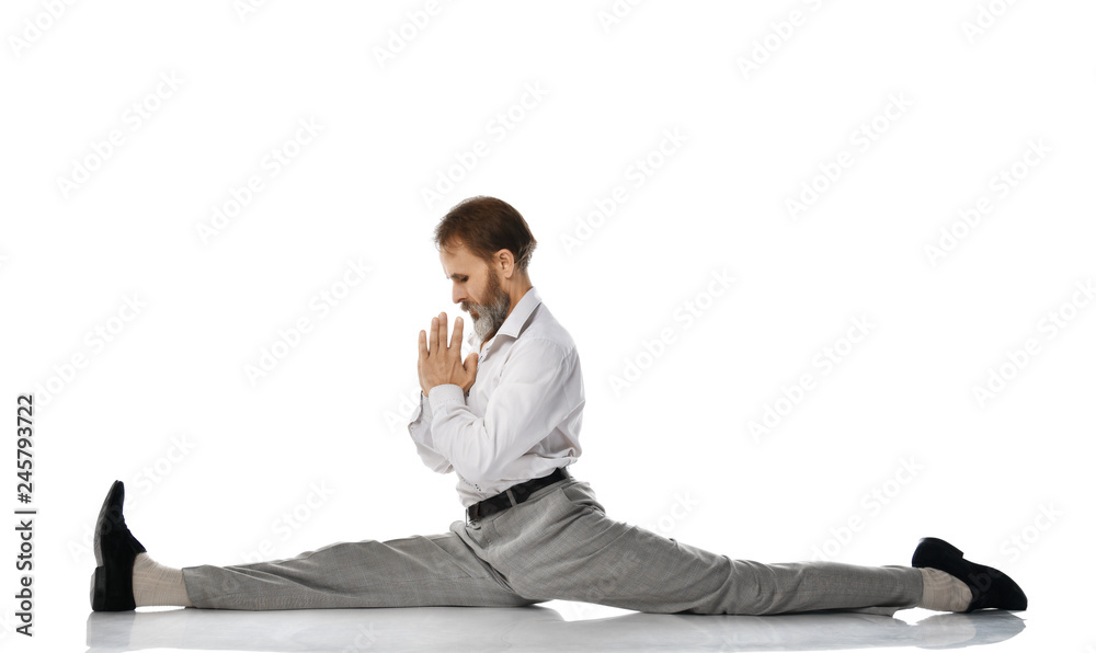 Old man practicing yoga classic asana pose do the splits against white ...