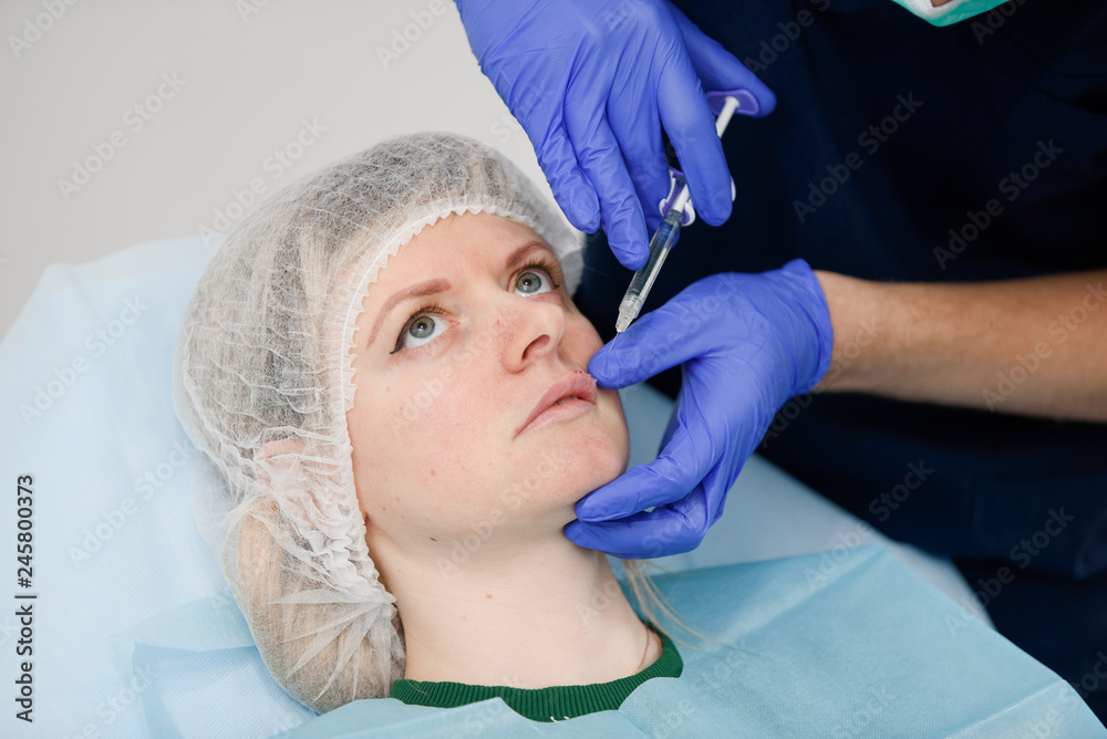 girl do plastic operation in medical clinic; doctor does lip ...