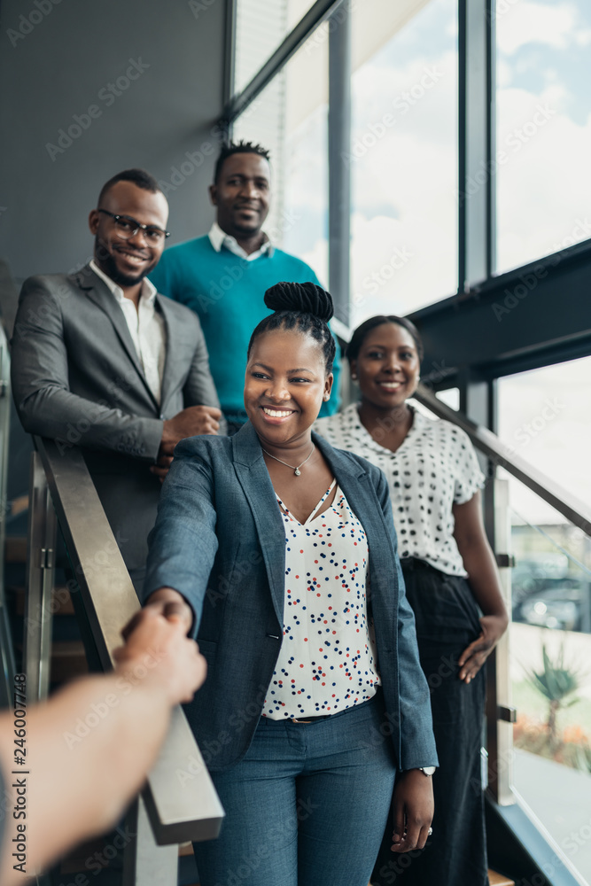 Smiling confident black businesswoman greeting and shaking hands with ...