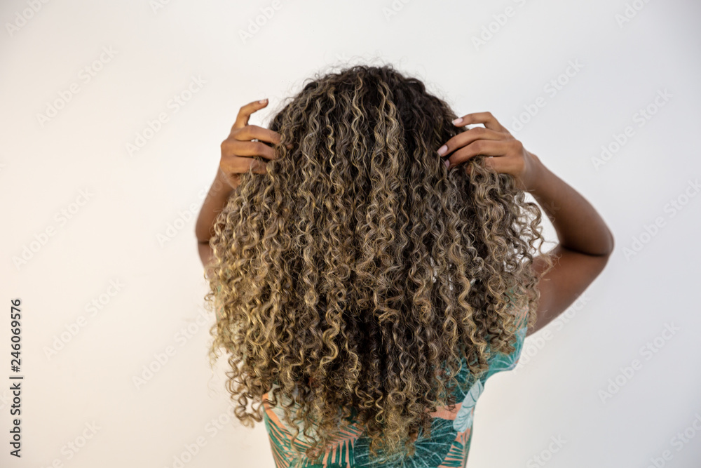 Young black woman on her back with afro hairstyle on white background ...
