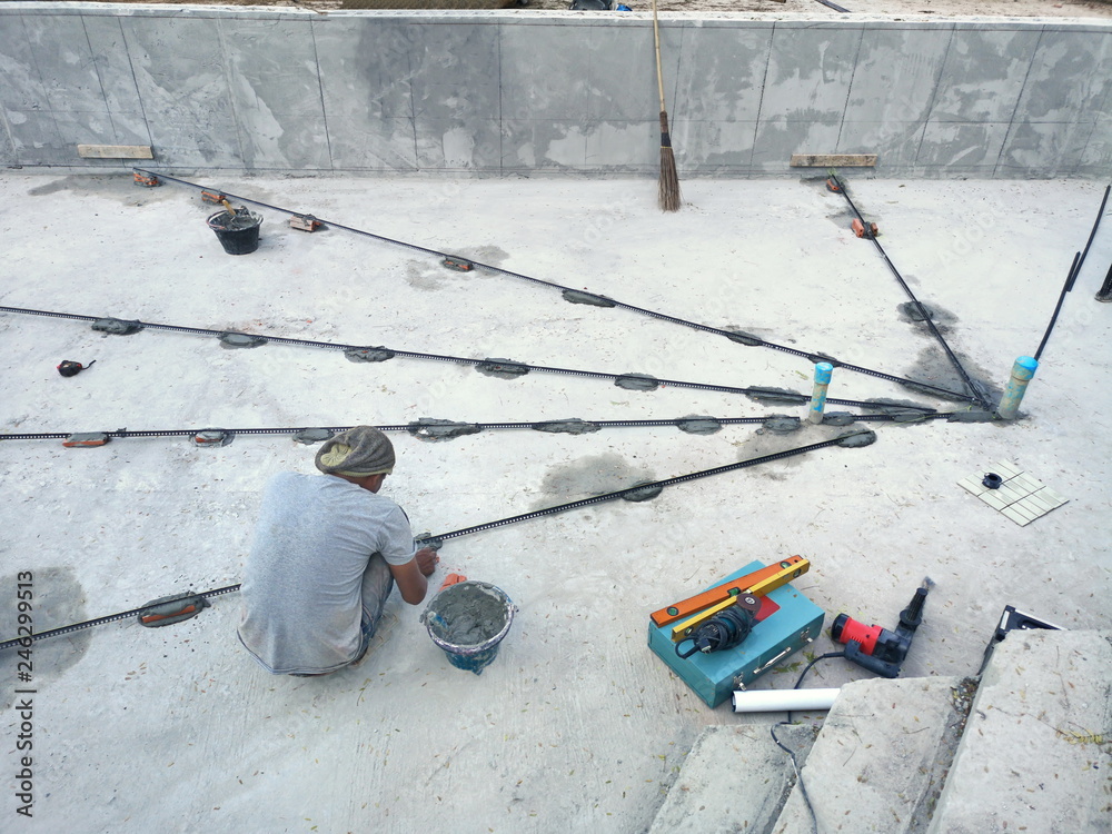 Swimming pool construction.The technician is installing a vertical line ...
