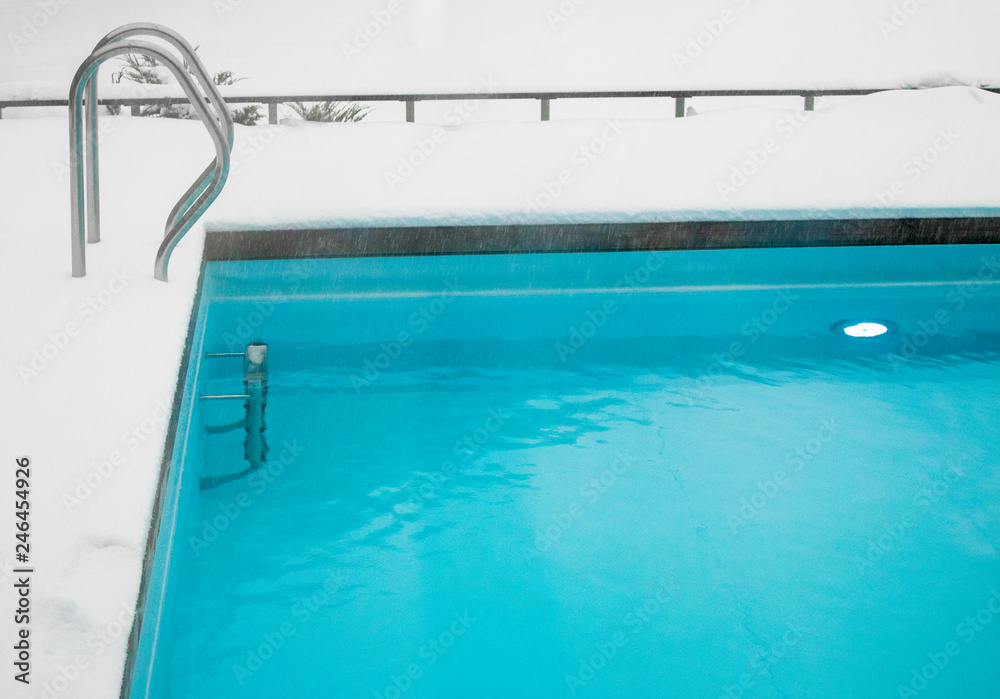 Beautiful blue color swimming pool in winter, poolside covered with ...