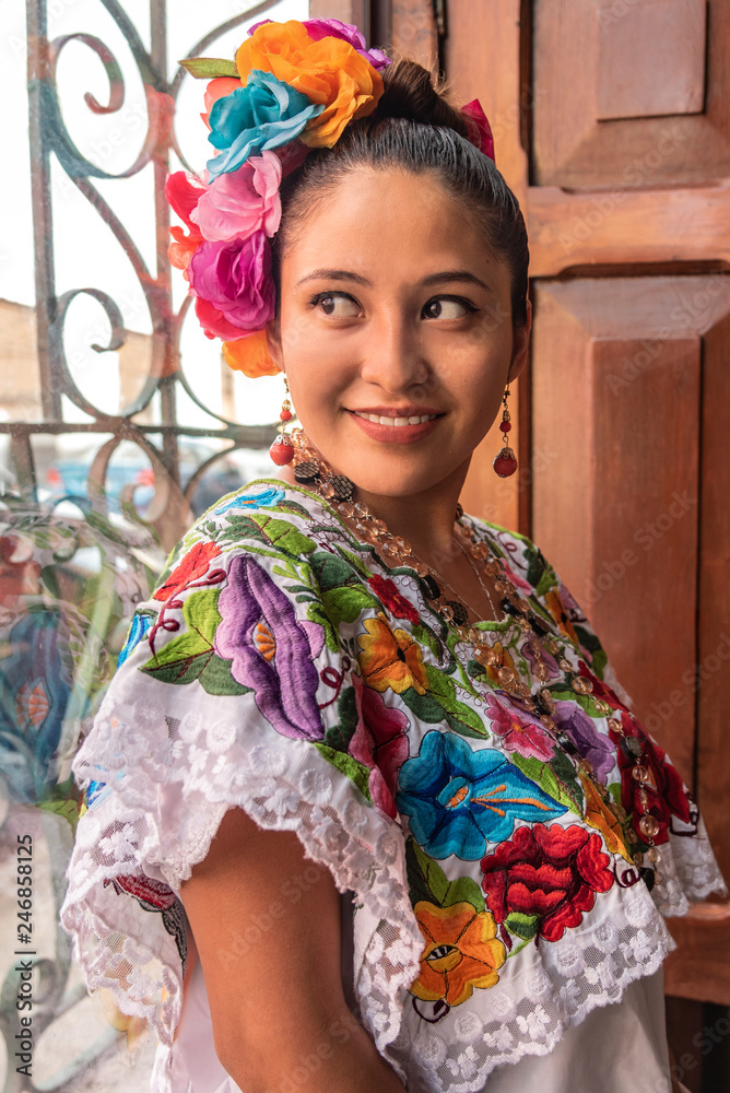 Pretty and colorful Mayan girl in Yucatan. Young smiling girl inviting ...