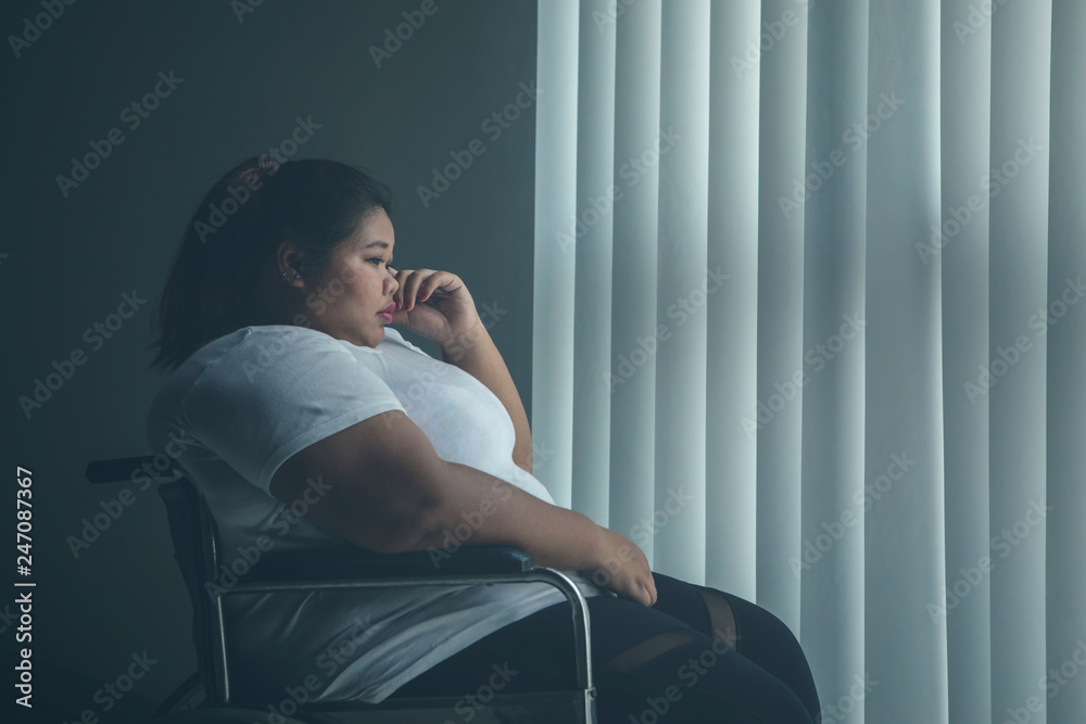 Overweight woman looks sad in the wheelchair Stock Photo | Adobe Stock