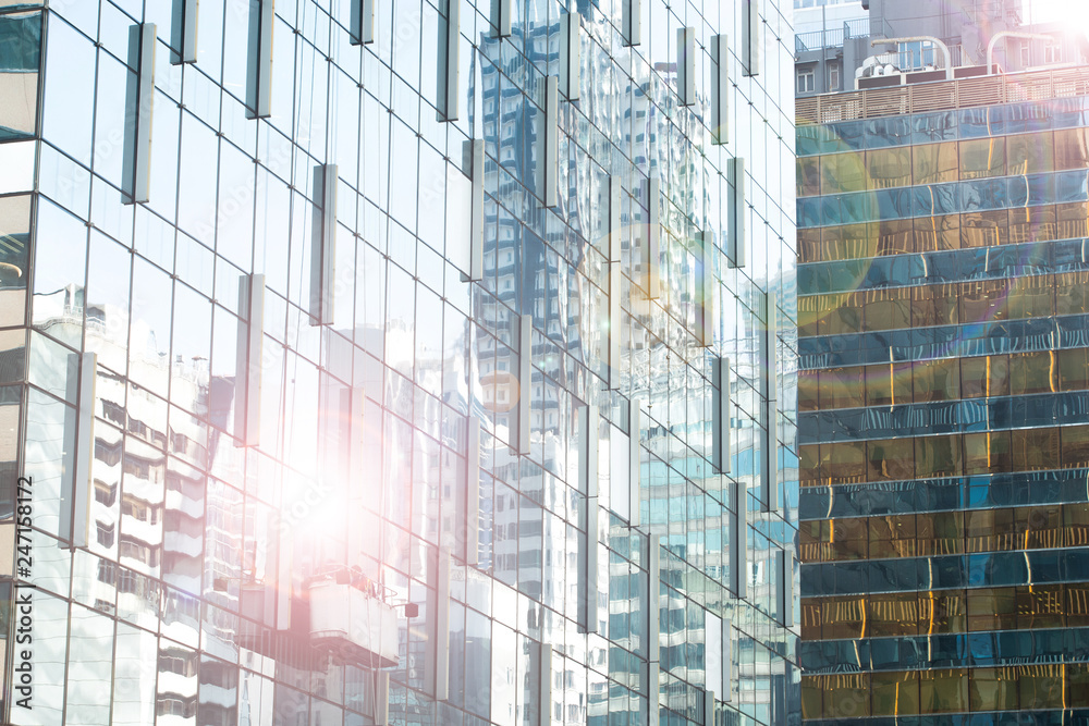 Workers crane cradle clean windows glass of high building under sun day ...