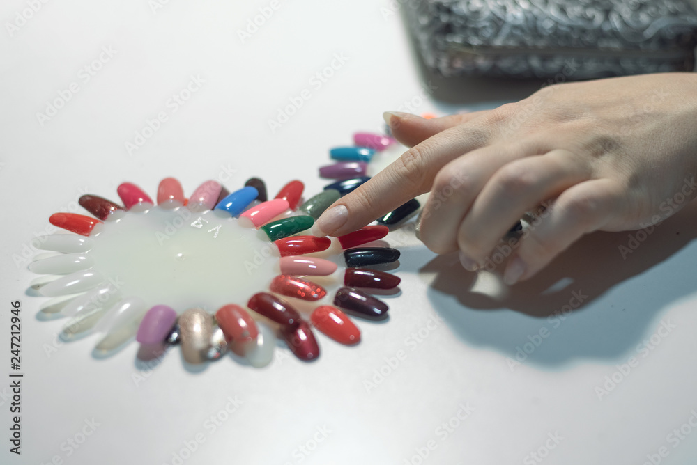 Woman chooses the color of nail polish on the color wheel and points ...
