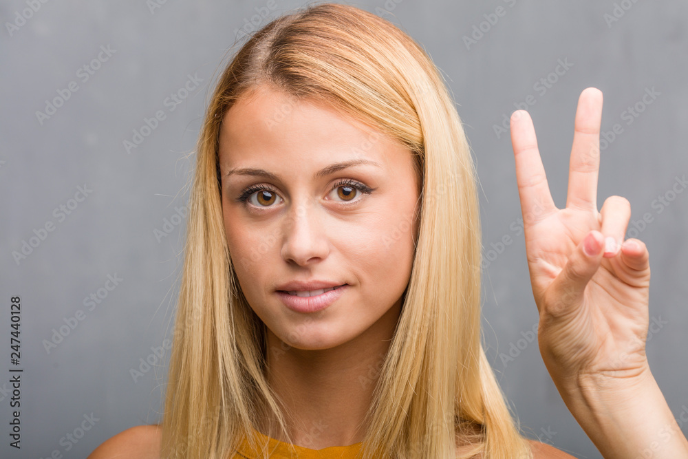 Face closeup, portrait of a natural young blonde woman showing number ...