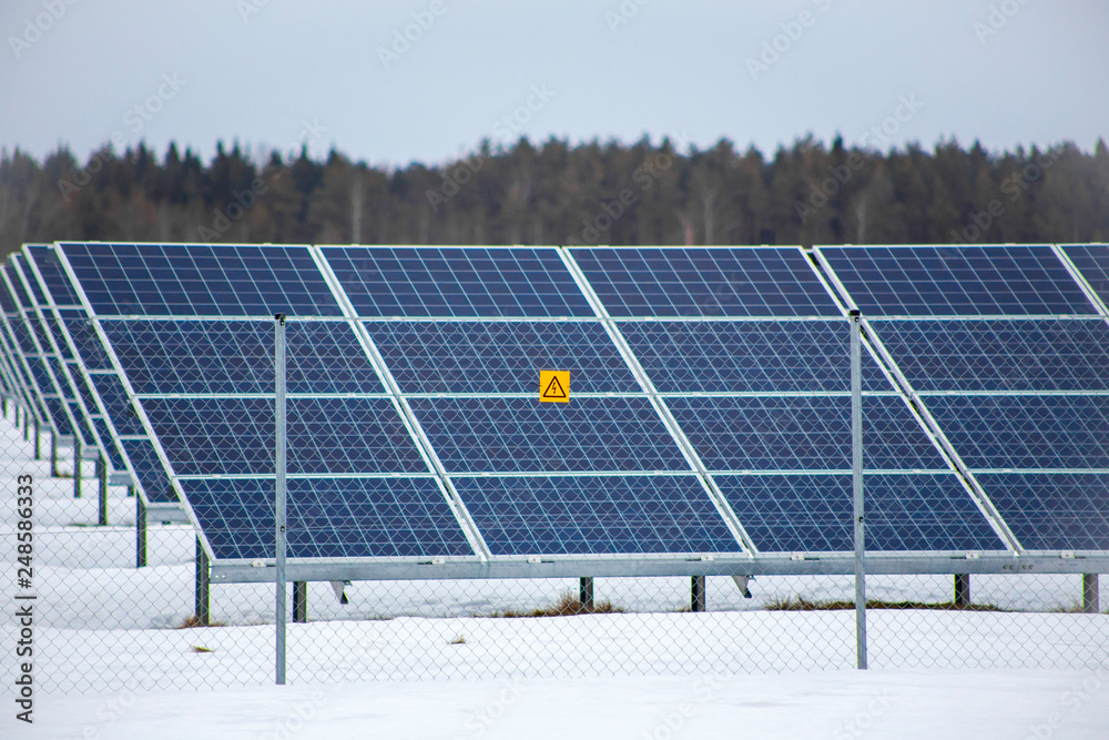 Industrial solar power farm station on field in rural area in winter ...
