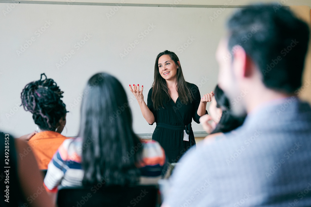 Smiling teacher explaining students in classroom Stock Photo | Adobe Stock