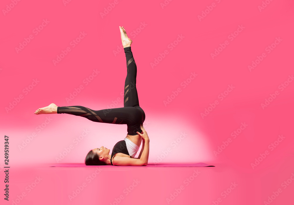 Long haired beautiful pilates or yoga athlete does a graceful pose ...