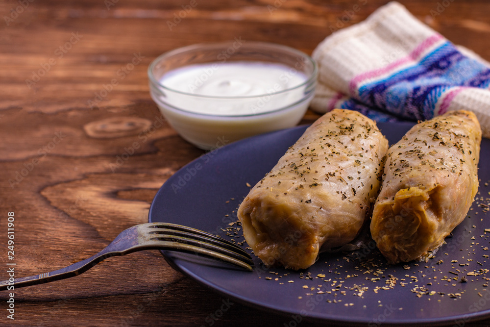 Hot cabbage rolls with rice, meat with sour cream in a clay dish. Kelem ...