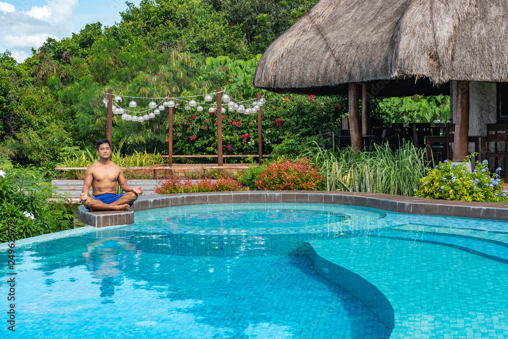 Filipino male doing yoga poses poolside Stock Photo | Adobe Stock