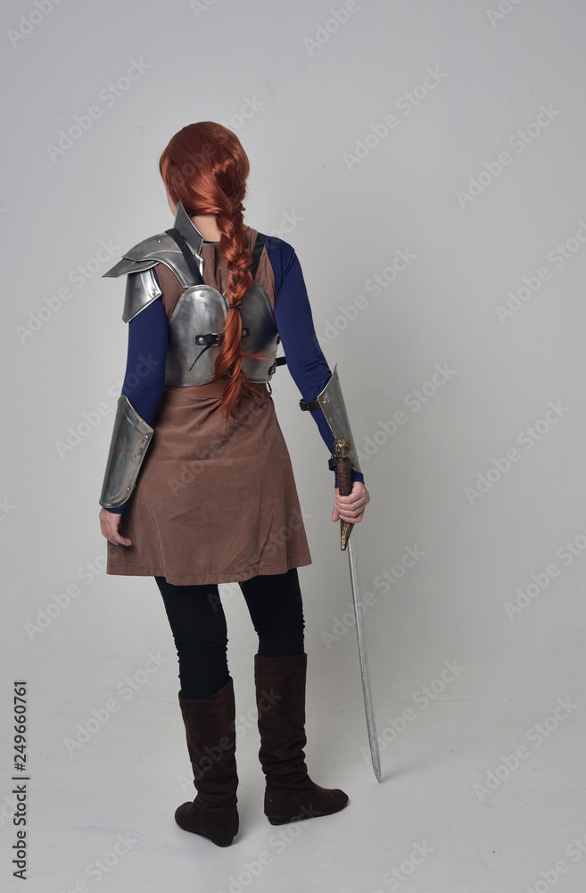 Foto de Stock full length portrait of a red haired girl wearing ...